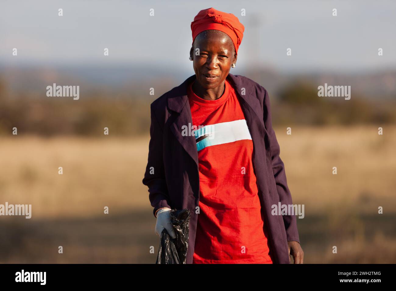 village african old woman cleaning the trash community service ...