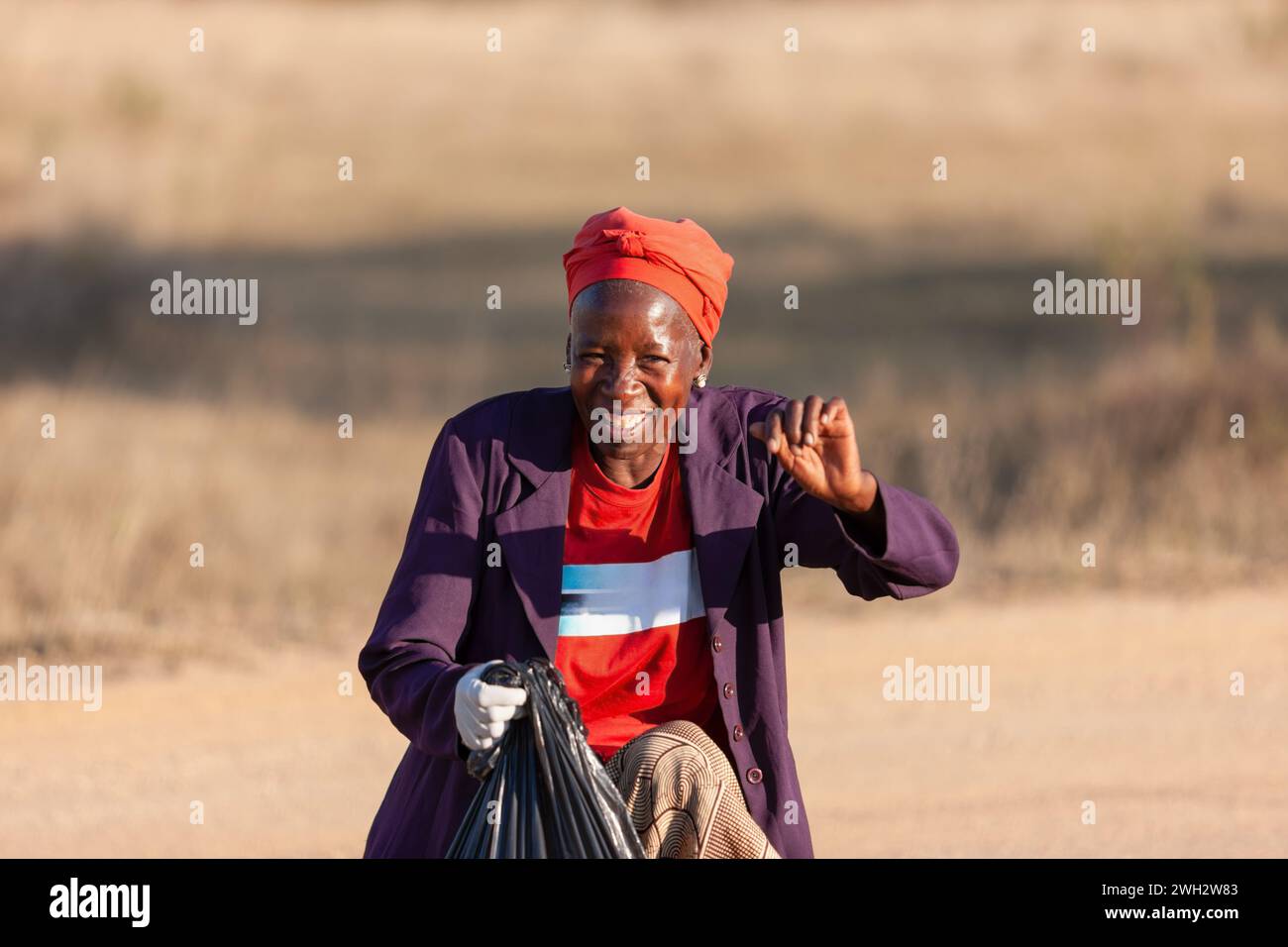 village african old woman cleaning the trash community service ...