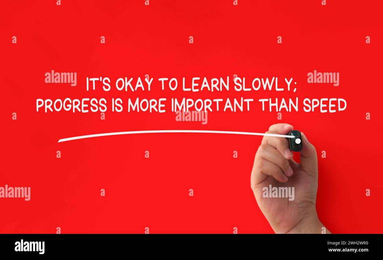 Hand writing It is okay to learn slowly affirmation on red cover ...