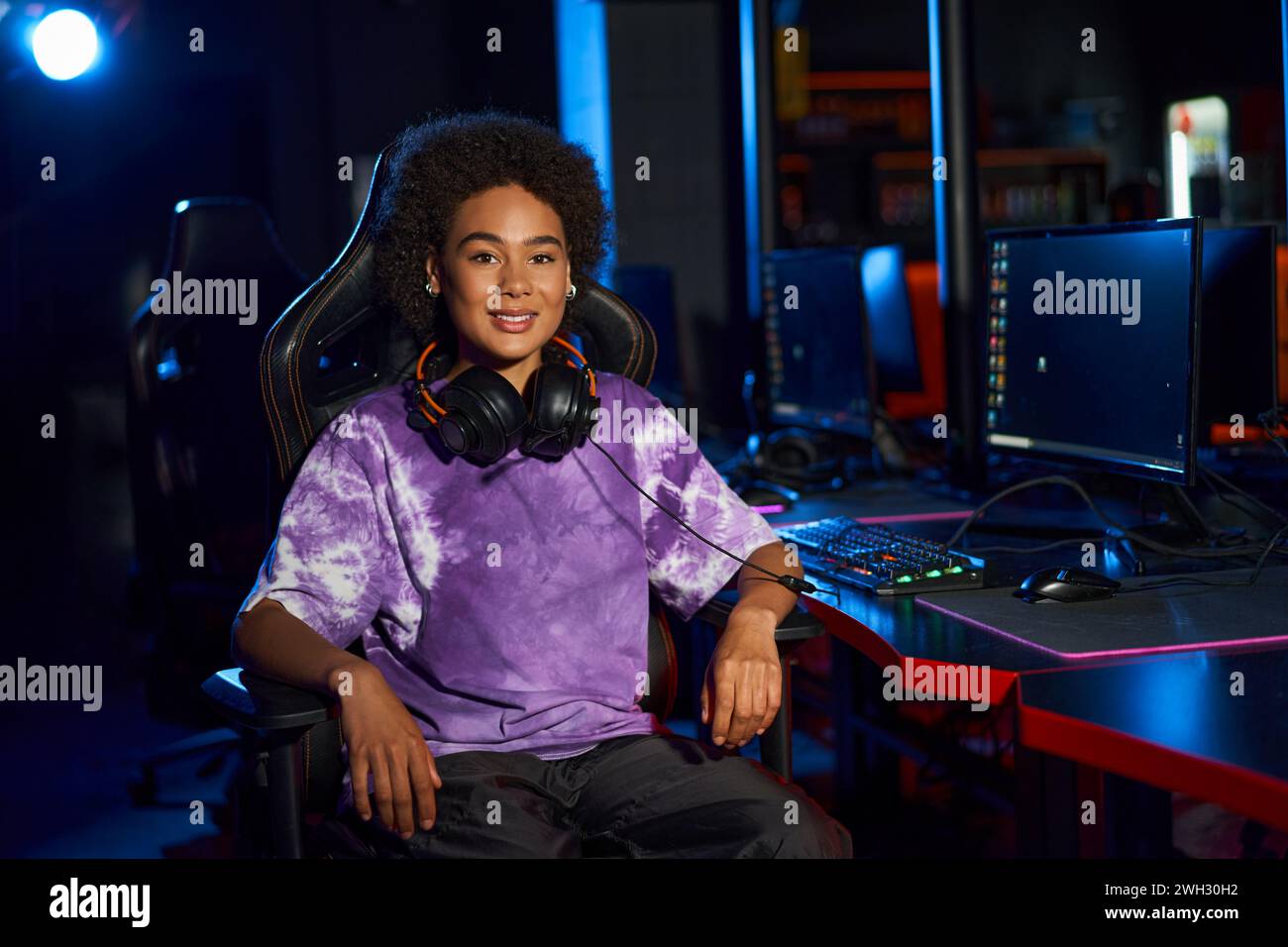 happy african american female gamer with headphones sitting on ...
