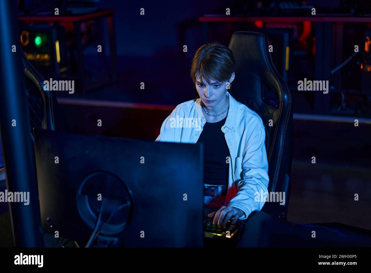 focused woman looking at monitor while playing multiplayer computer ...