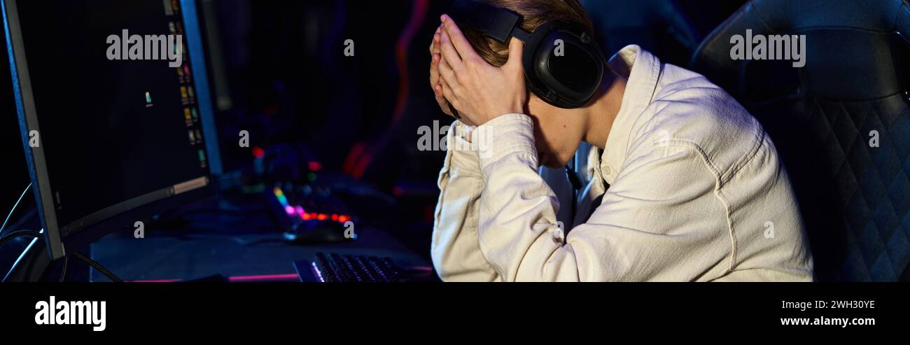 upset gamer in headphones with hands on face after a losing cybersport ...