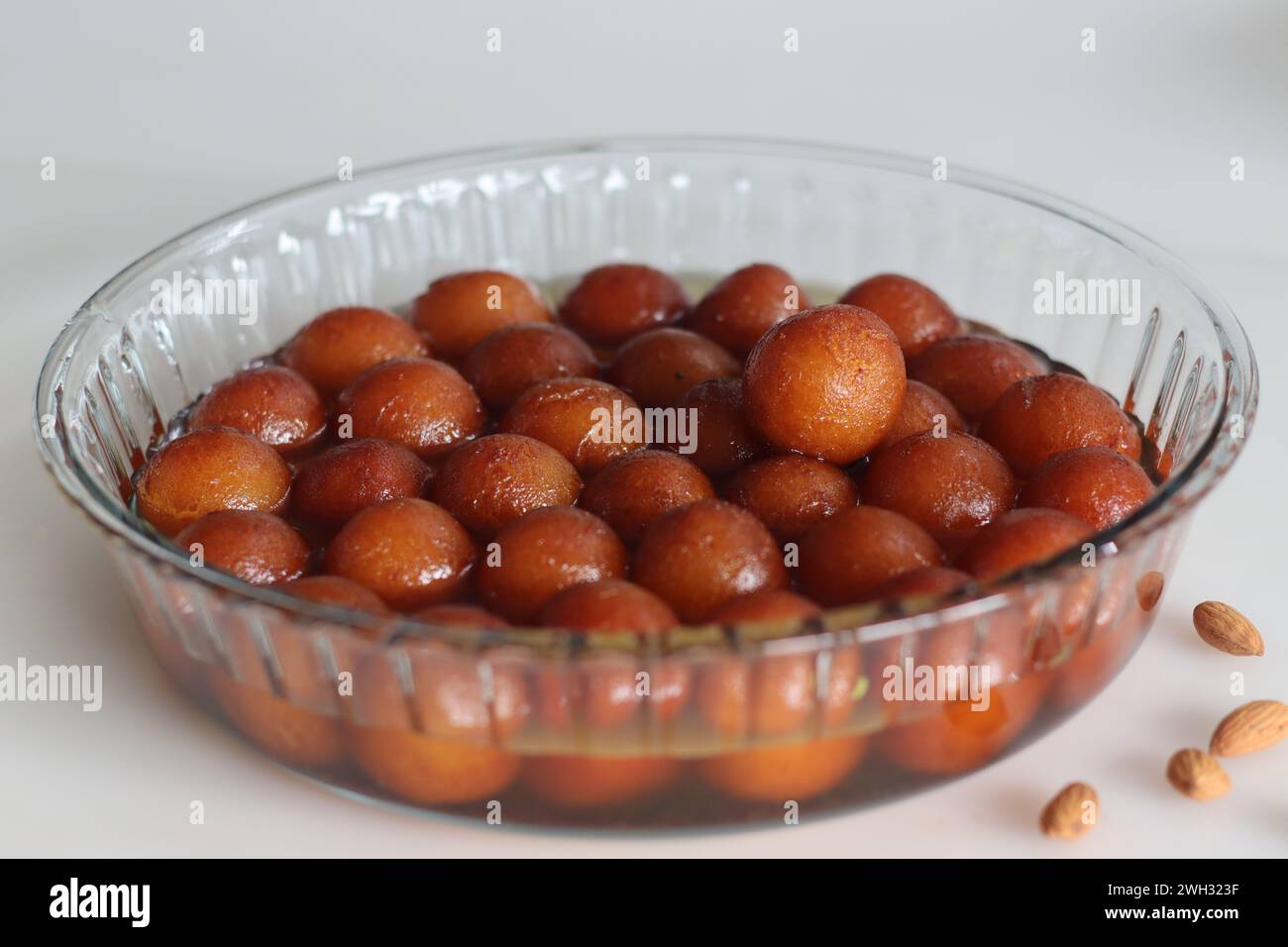 Delectable Gulab Jamun dessert on a rustic plate. Close up of golden ...