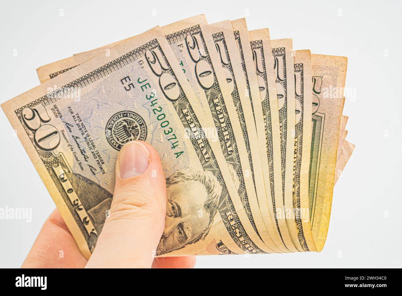 Several 50 dollar bills in hand. Man hand with dollars isolated on a ...