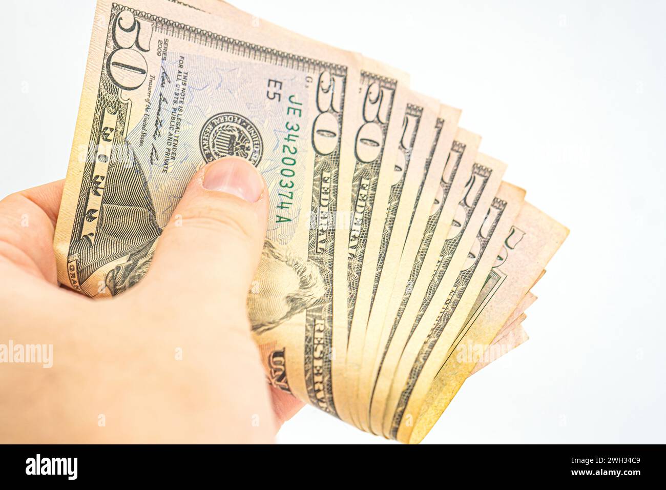 Several 50 dollar bills in hand. Man hand with dollars isolated on a ...