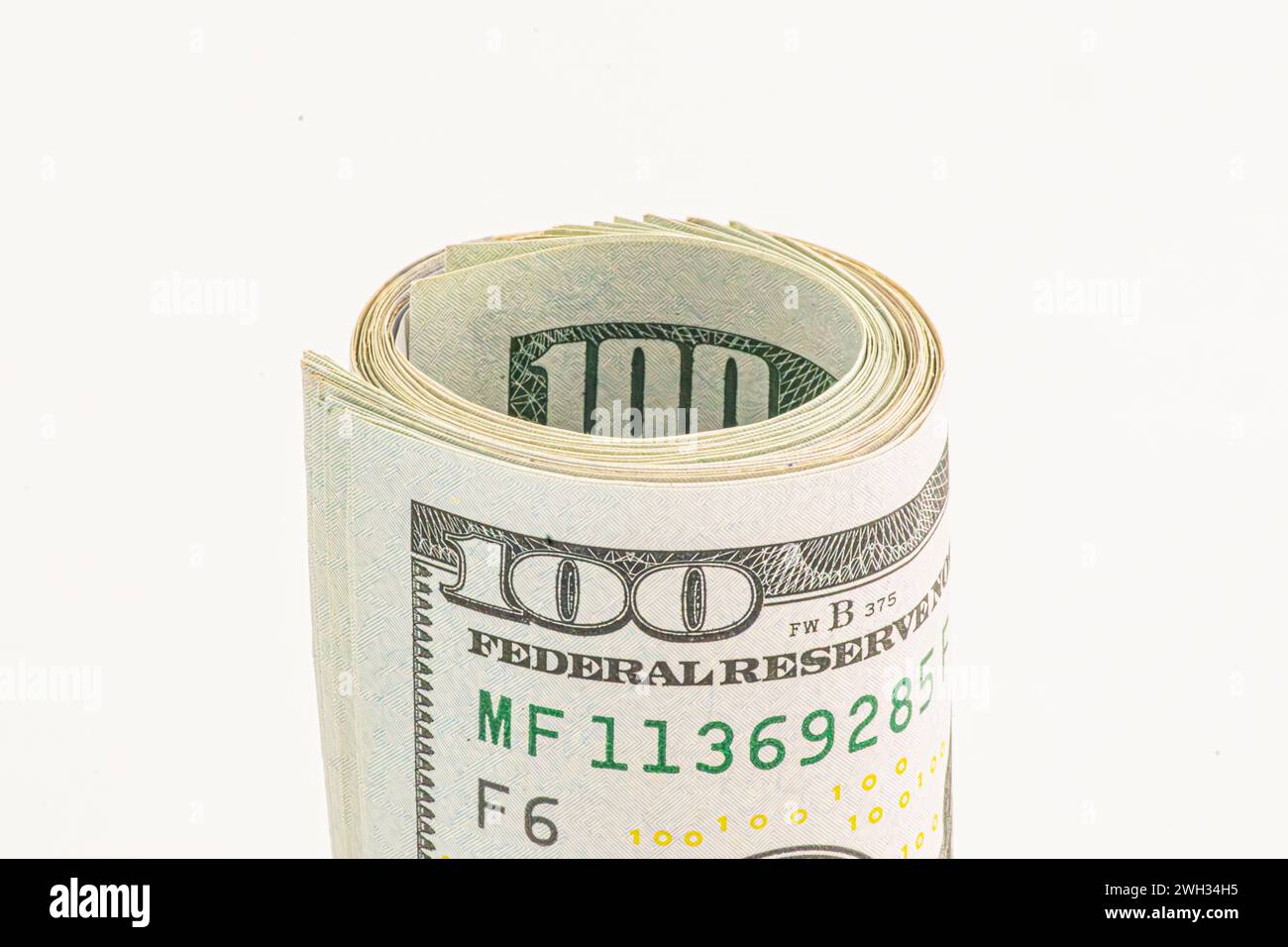 100 dollar bills on a roll isolated on white background. Rolled up ...