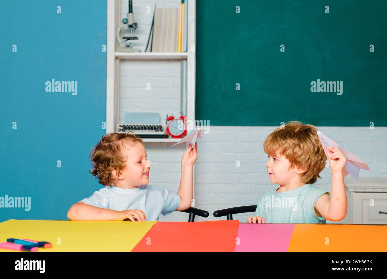 Funny toddlers from elementary school hold paper plane laughing and ...