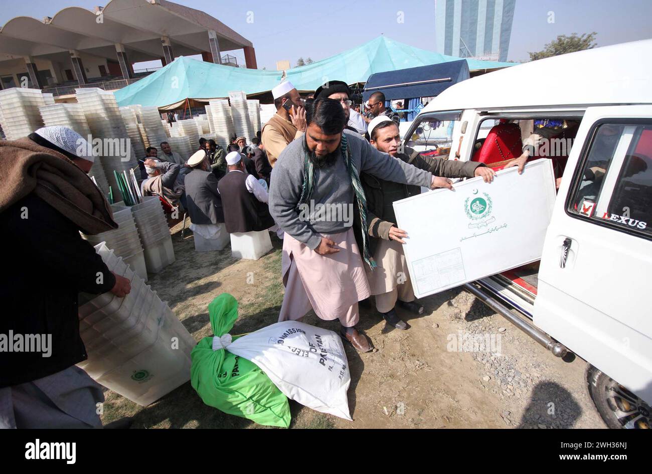 Polling staff carry ballot boxes and election materials for their ...