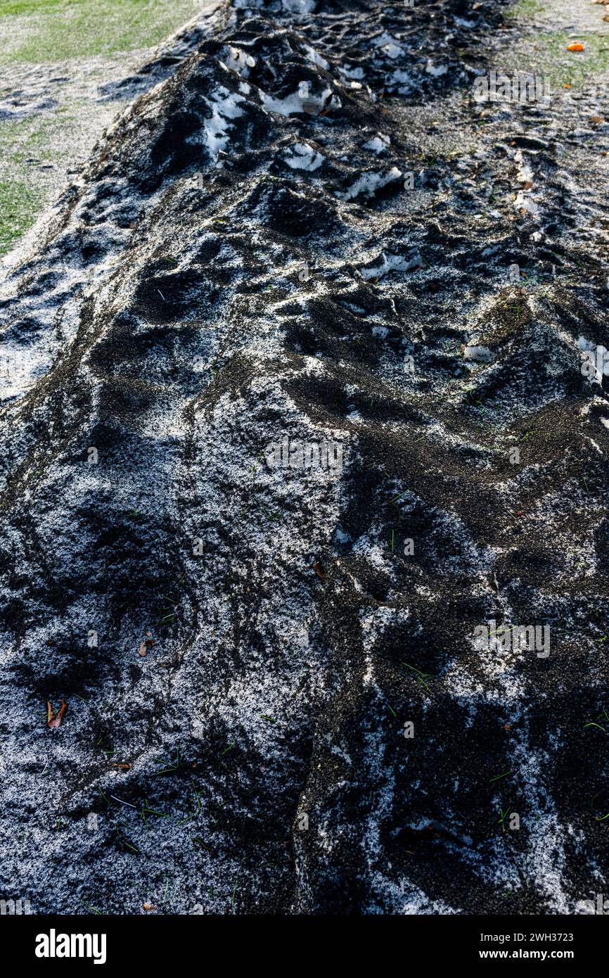 Artificial turf infill mixed with snow and ice by a football field ...