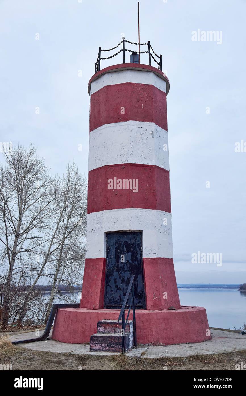 Small Lighthouse painted in red and white stripes with black door ...