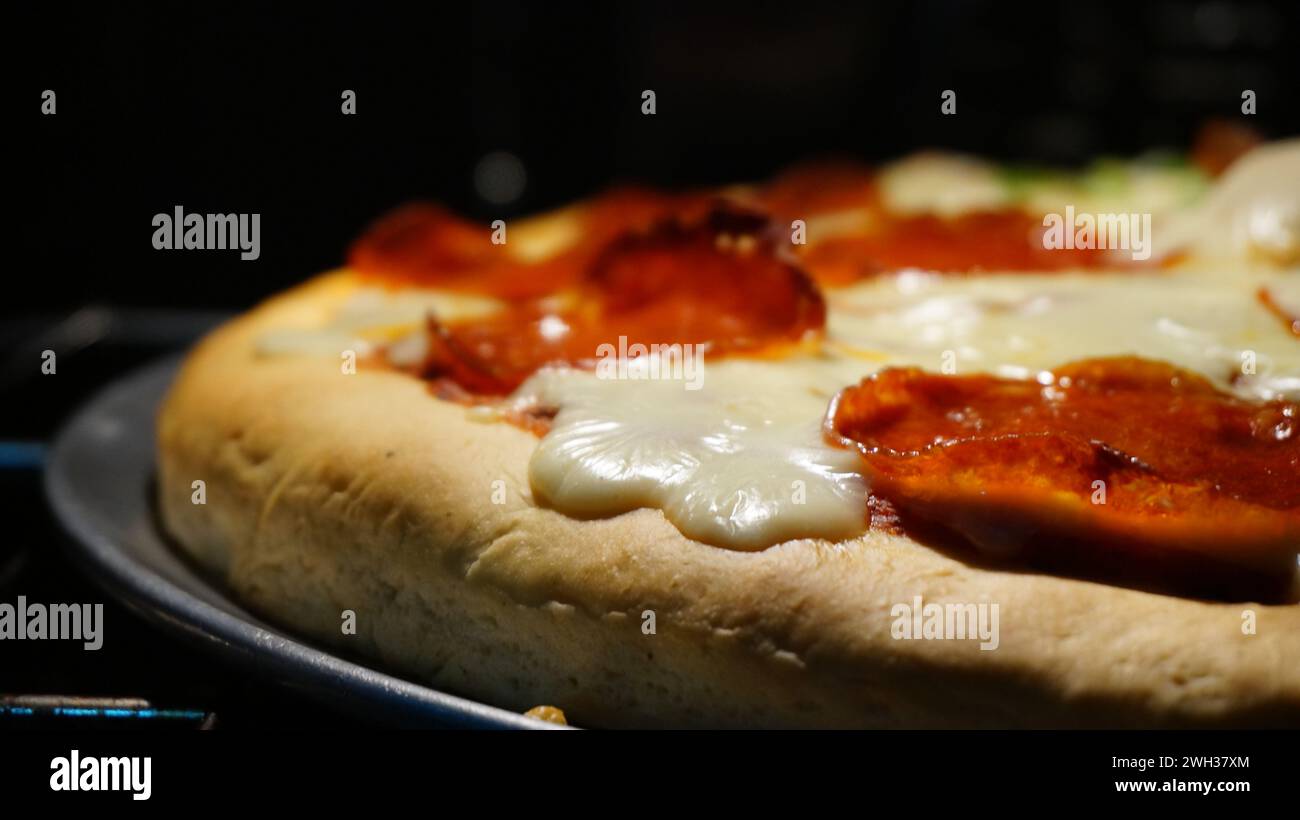 A delicious pepperoni pizza with lots of cheese in an oven Stock Photo ...