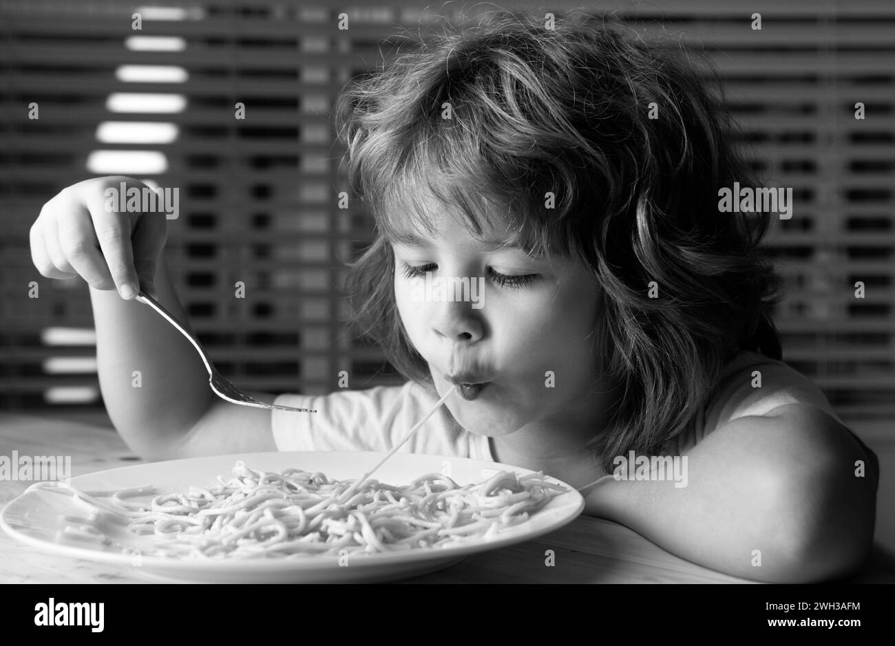Close up head shot of child eating pasta, spaghetti. Kids face, little ...