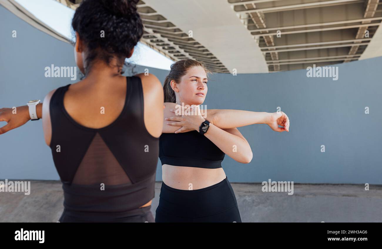 Two plus-size females in black fitness attire warming up. Young women ...
