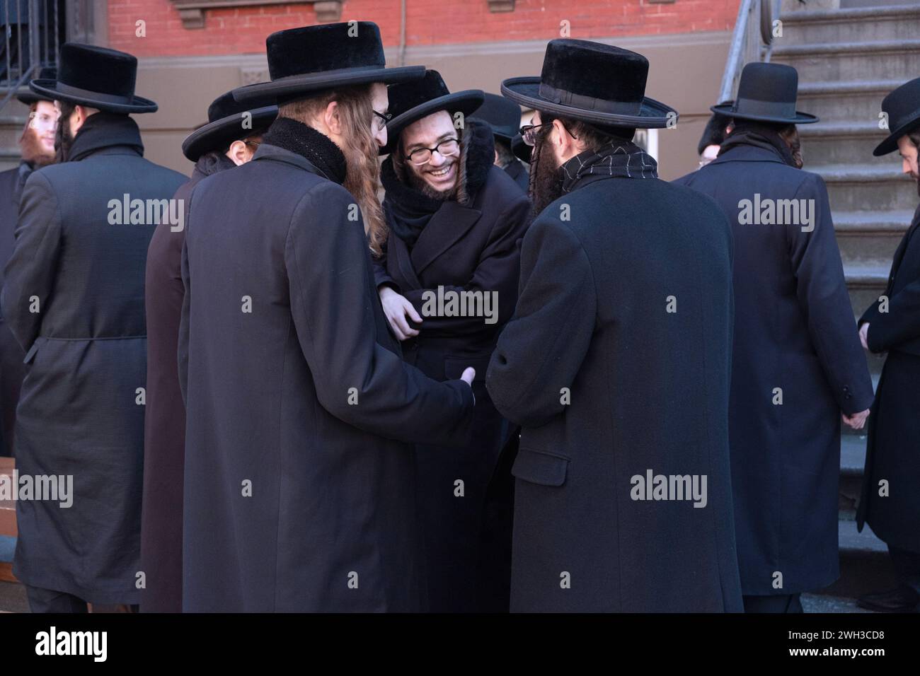 A group of Hasidic men who are dressed alike have a pleasant ...