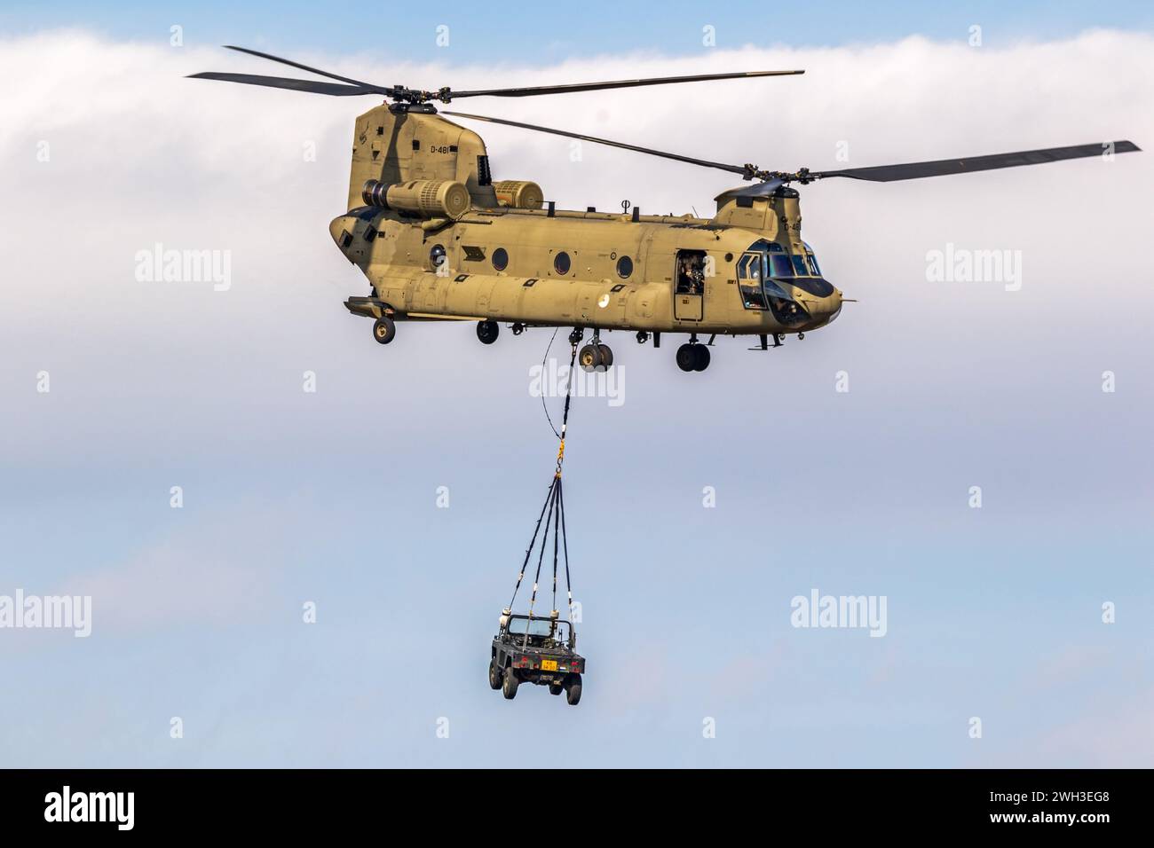 Boeing CH-47F Chinook transport helicopter with a slingload leaving in flight. Arnhem, The ...