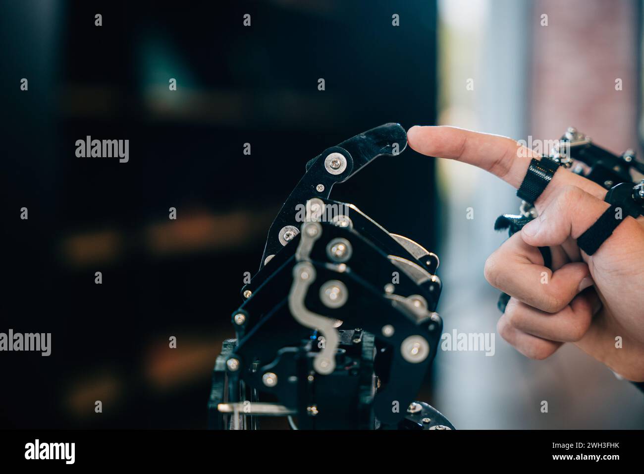 In a technical college a teenage boy tests a robot hand and arm ...