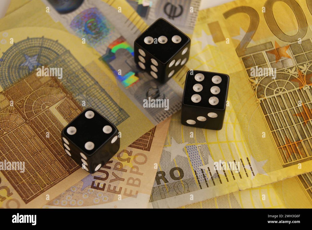 Three dice on 200 euro banknotes, close up Stock Photo - Alamy