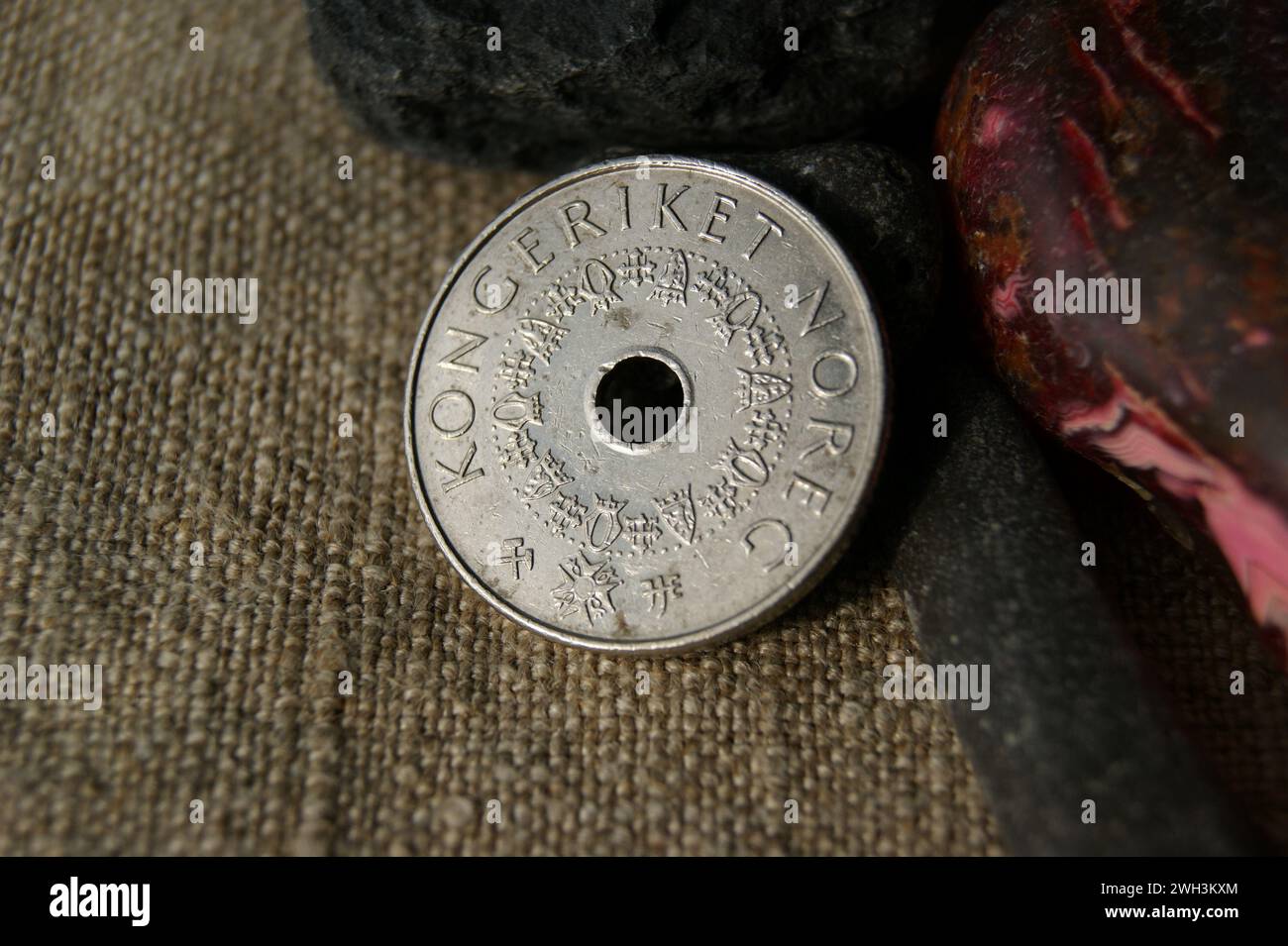 Norwegian coin on linen cloth. A coin with a hole Stock Photo - Alamy