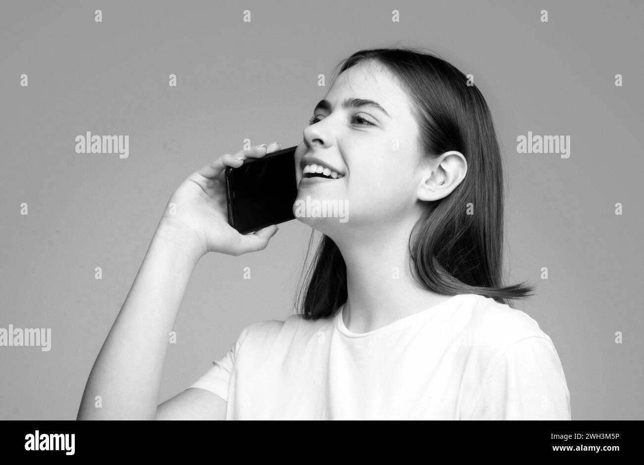 Cute beautiful young woman chatting by mobile phone isolated background ...