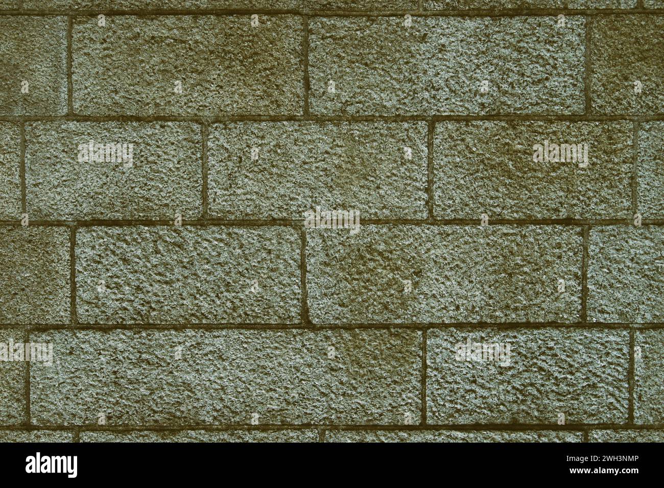 Rough old stone block wall. Green background Stock Photo - Alamy
