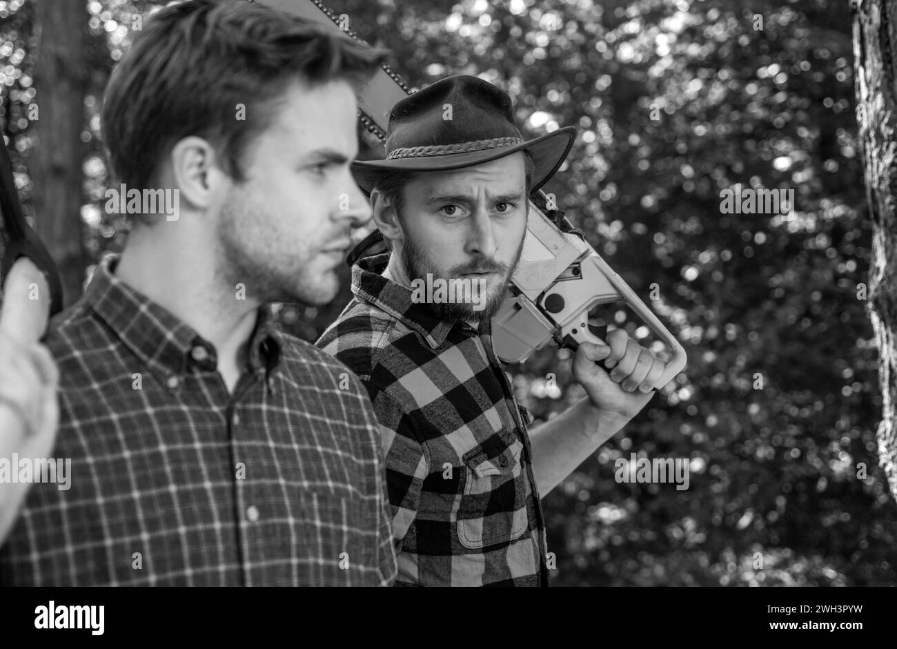 Two lumberjacks portrait with chainsaw and axe Stock Photo - Alamy