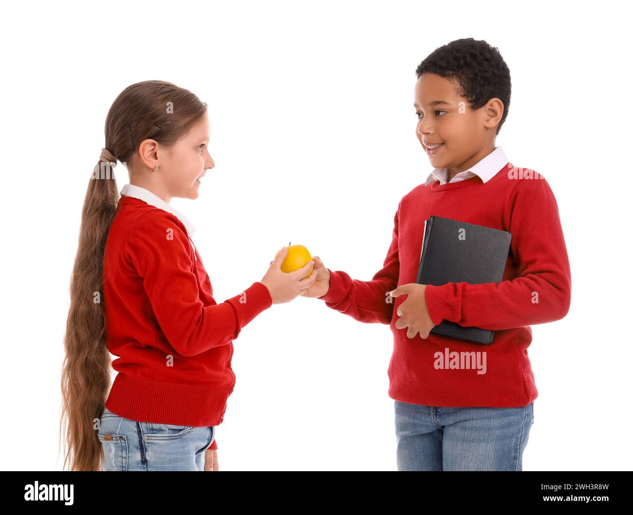 Little students with apple on white background Stock Photo - Alamy