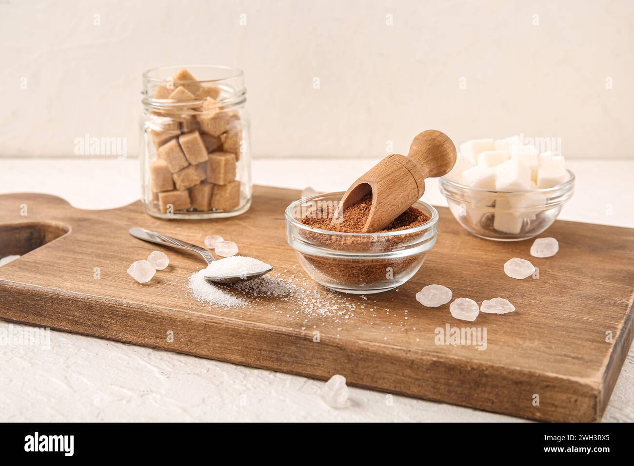 Wooden board with different types of sugar on white background Stock ...