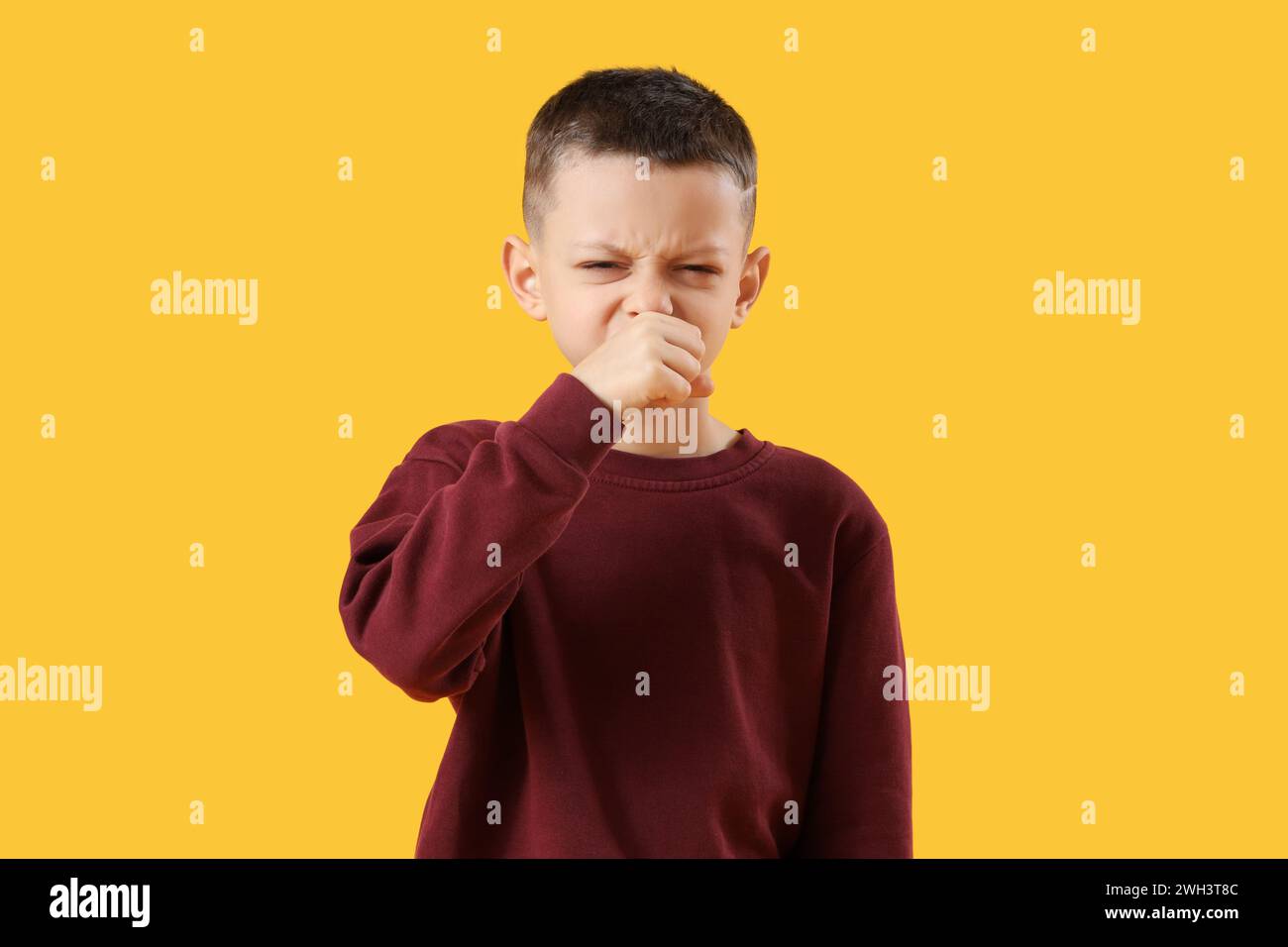 Ill little boy coughing on yellow background Stock Photo - Alamy