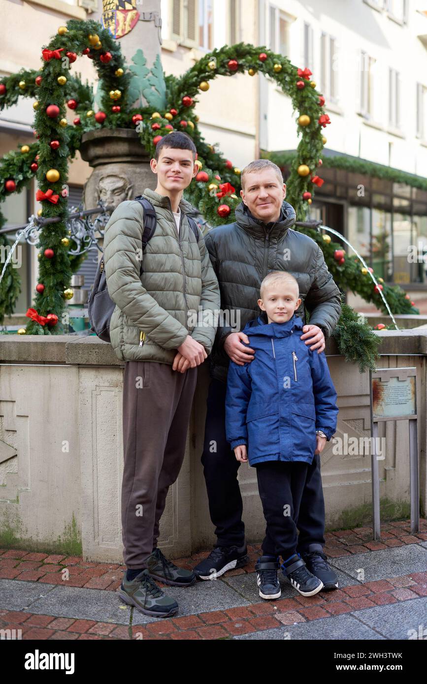 Joyful Family Portrait: Father and Two Sons by Festive Vintage Fountain ...