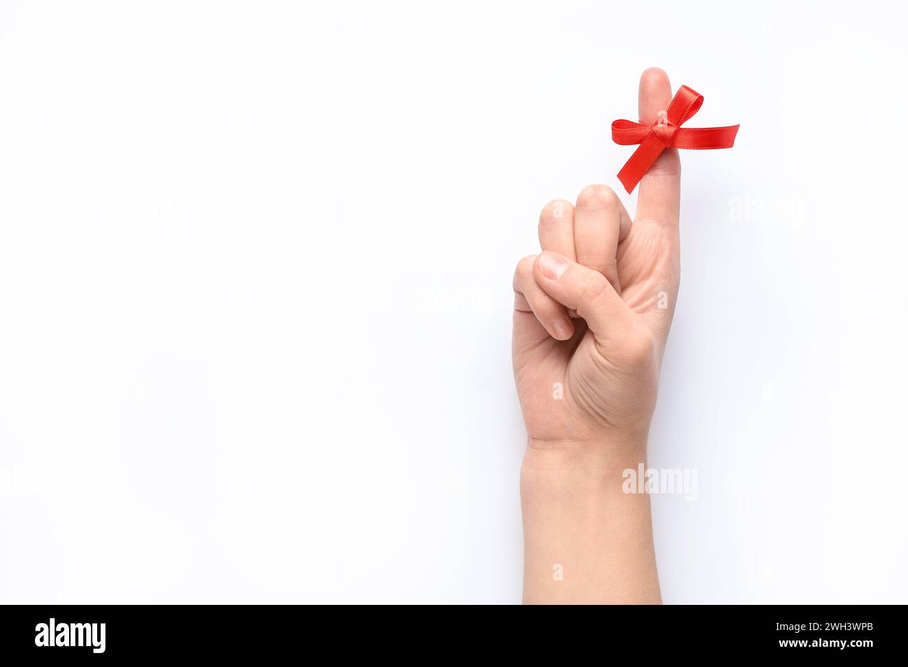 Female hand with red bow on index finger against white background ...