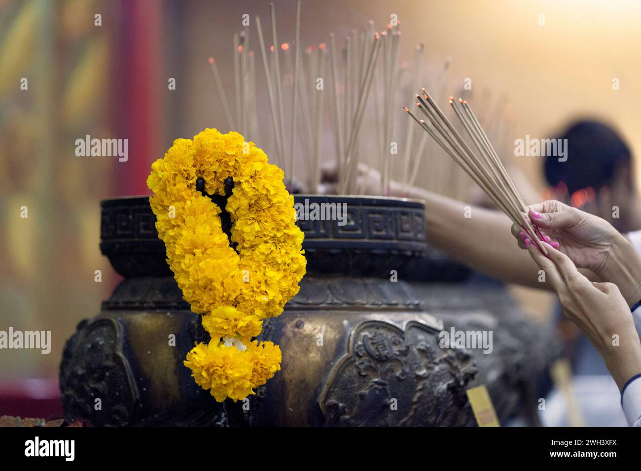 Prayers burning incense sticks and offering garland of flowers at Wat ...