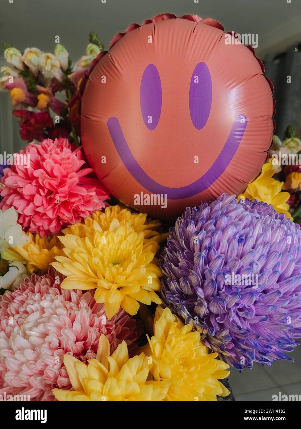 Smiley face balloon and flowers Stock Photo - Alamy
