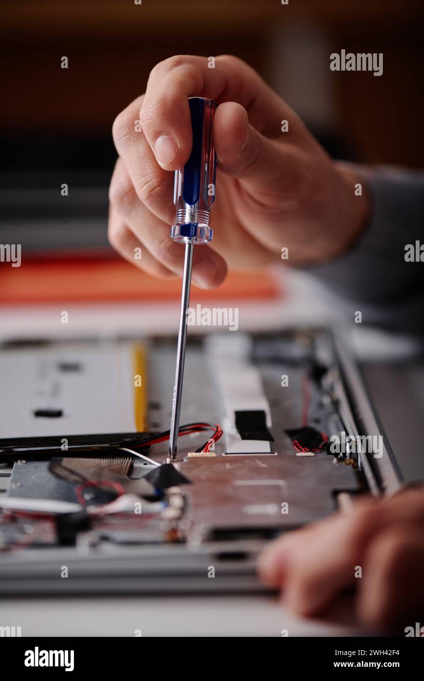 Hand of unrecognizable electronic repairman fixing element of ...