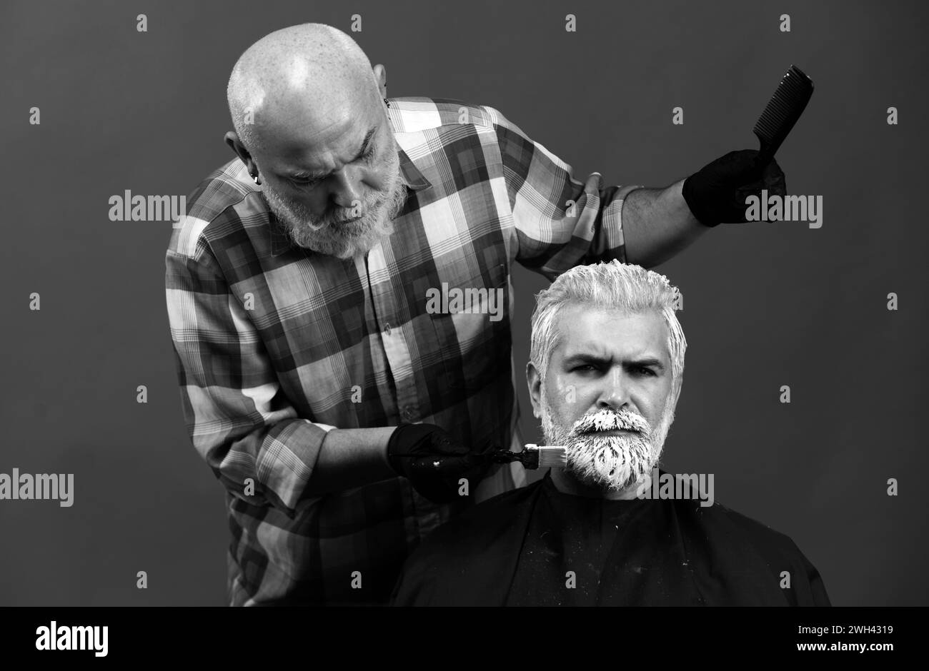 Bearded man coloring hair. Hair salon, hair coloring man. Attractive ...