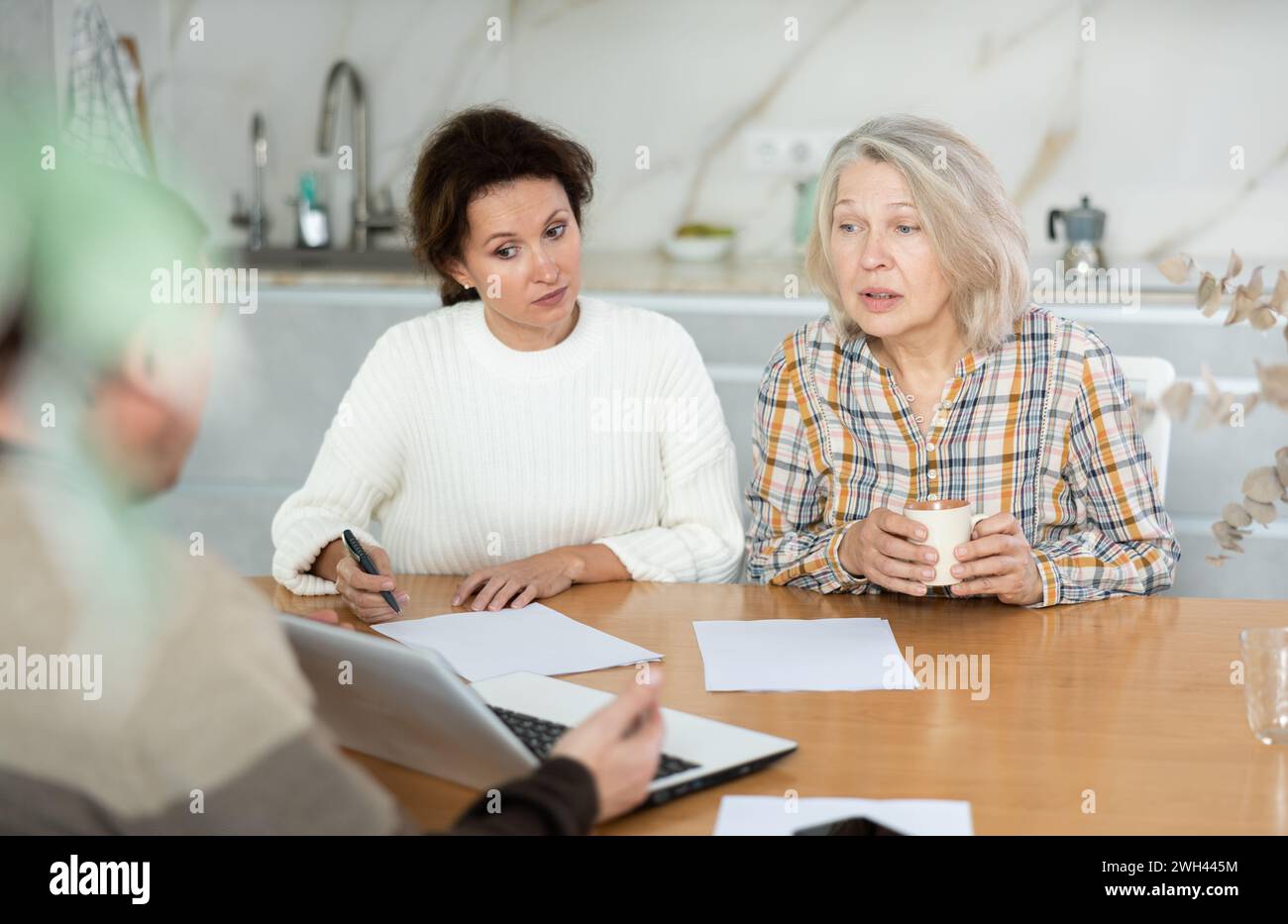 Mother and daughter considering offer from agent Stock Photo - Alamy