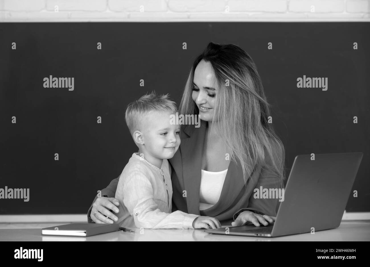 Little school child son using laptop with mother. Elementary school ...