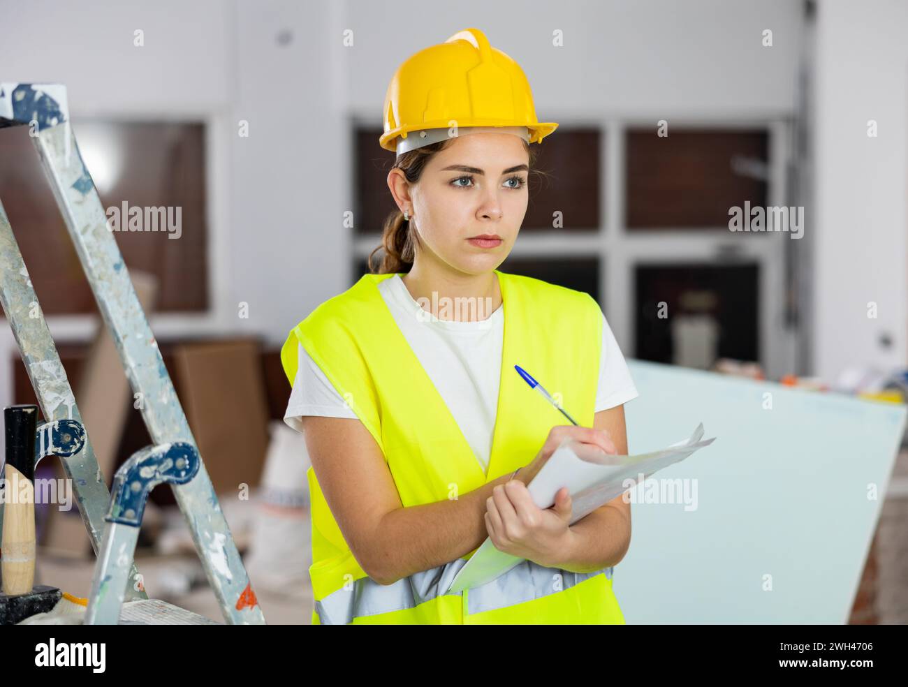 Focused female safety inspector making notes at construction site Stock ...
