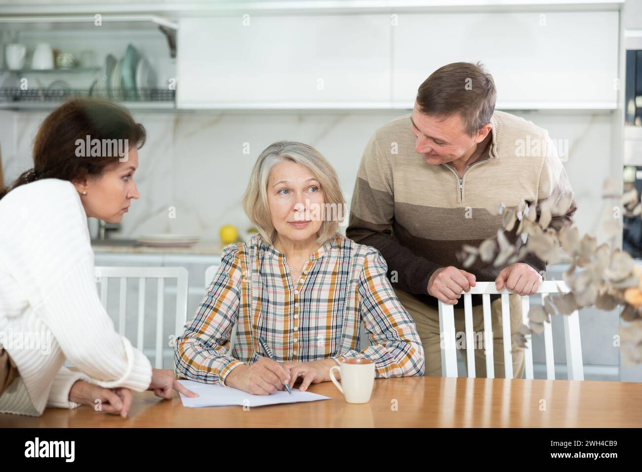 Old woman signing papers Stock Photo - Alamy