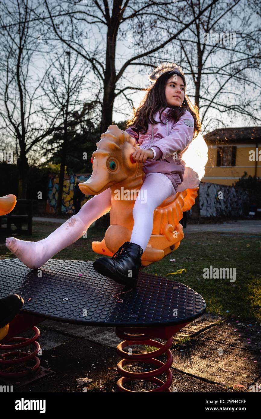 having fun on children playground girl in angel carnival costume with ...