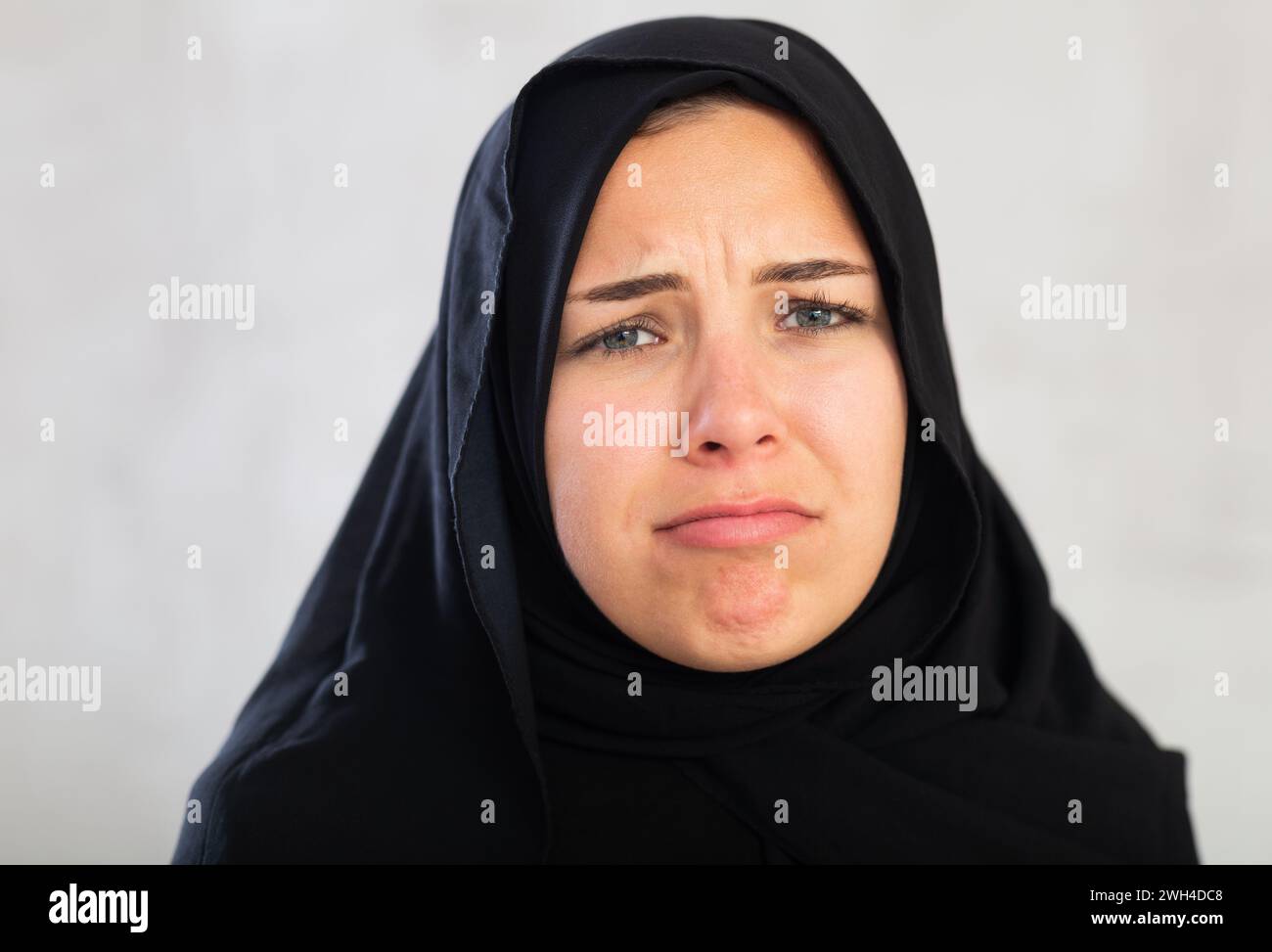 young Muslim woman in black hijab is upset by bad news and dejectedly ...