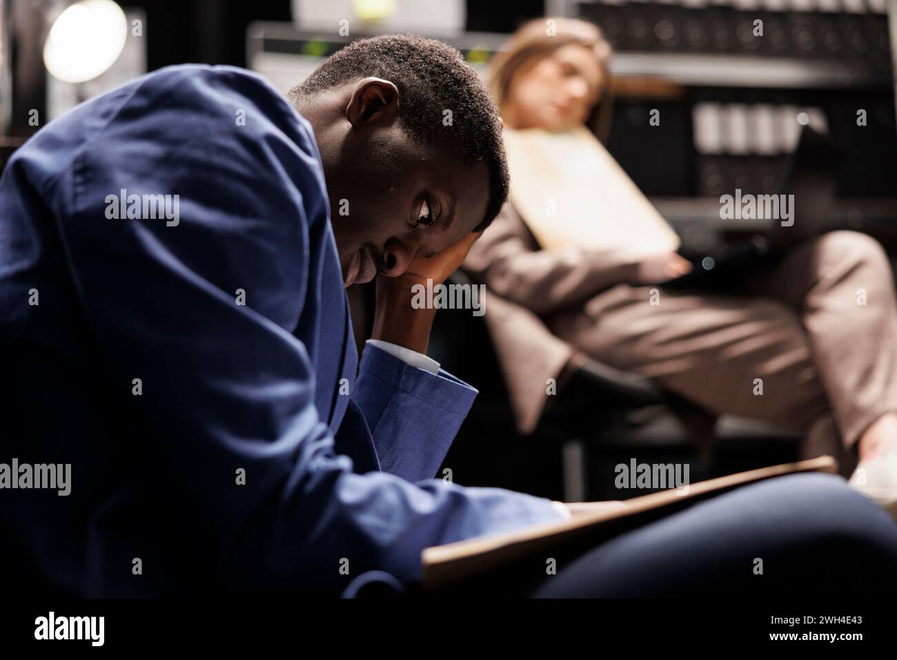 Tired private inspectors checking files with crime scene evidence ...