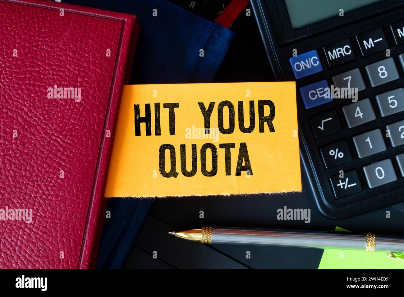 Closeup on businessman holding a card with text HIT YOUR QUOTA ...