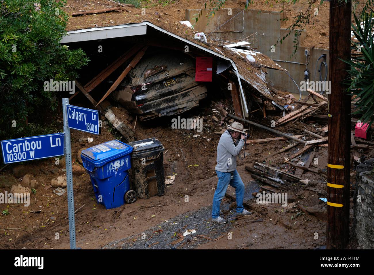 A local news photographer takes photos of a destroyed home and a ...