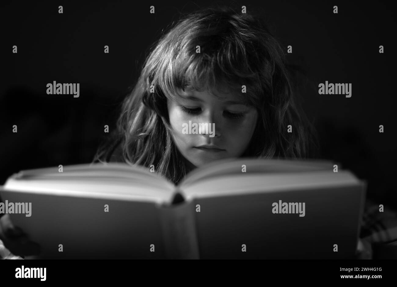 Child reading a magic book in bed. Kid boy read books at home ...