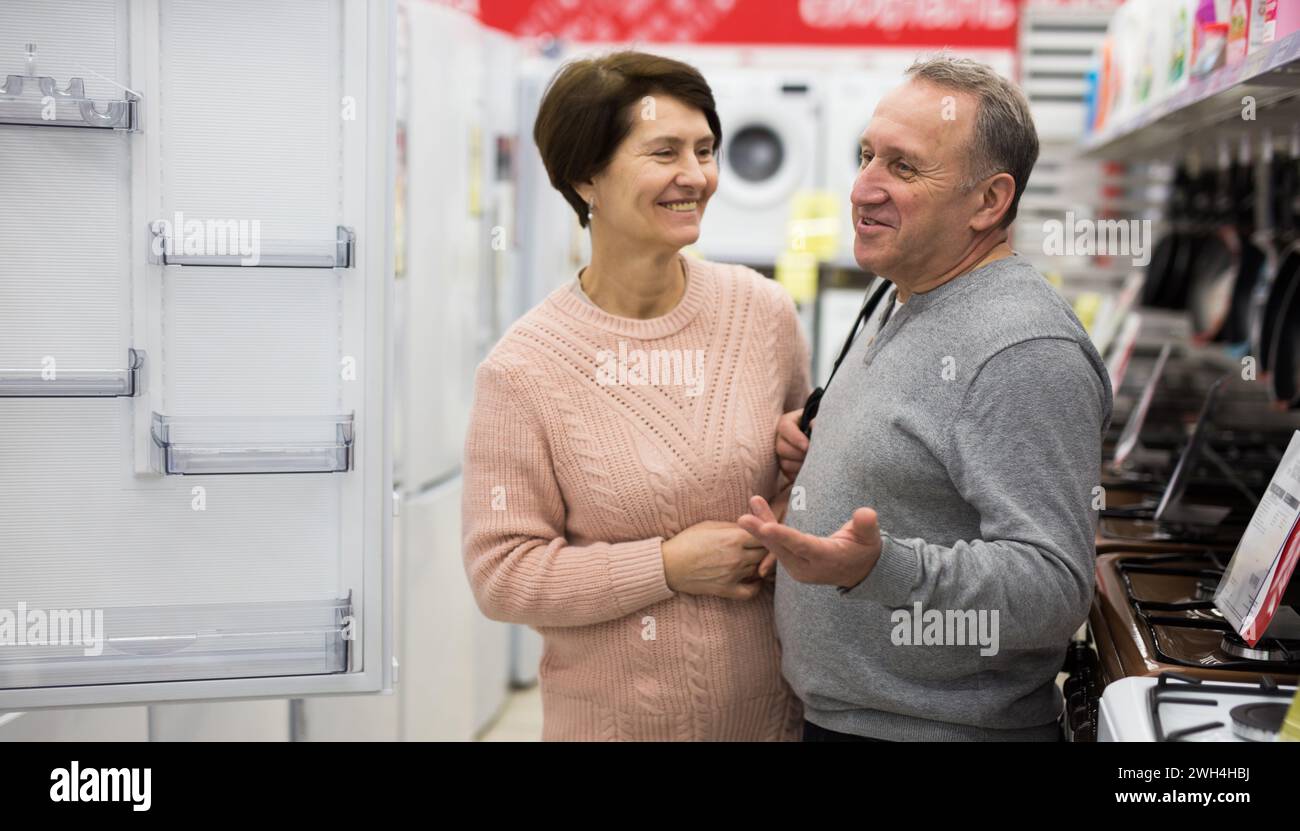 Middle aged wife and husband picking new refrigerator in store Stock ...