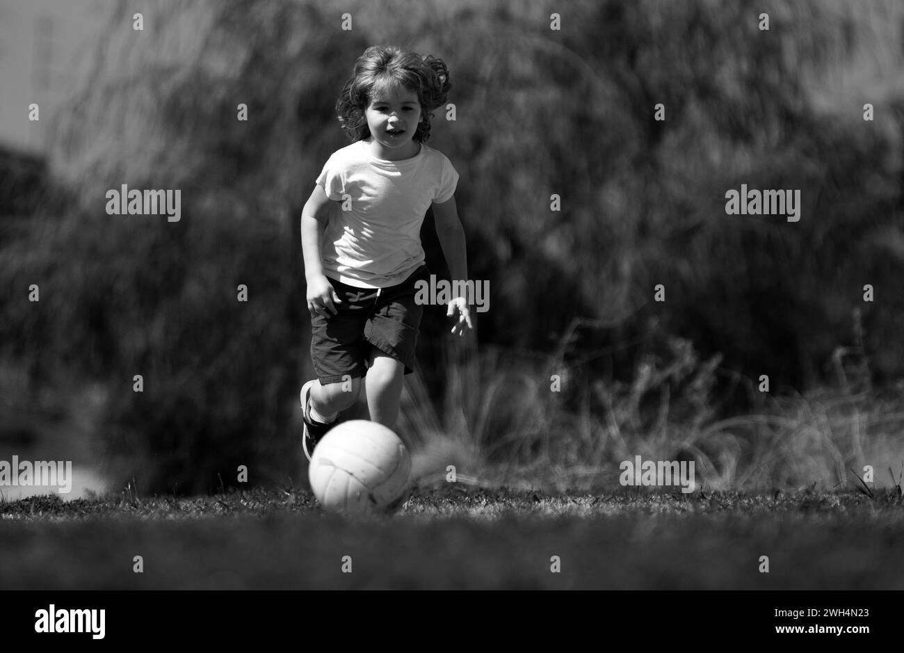 Boy child playing football on football field. Kid playing soccer. Child ...