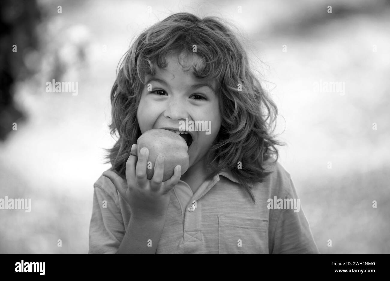 Healthy eating. Happy little child holding apples in summer green park ...