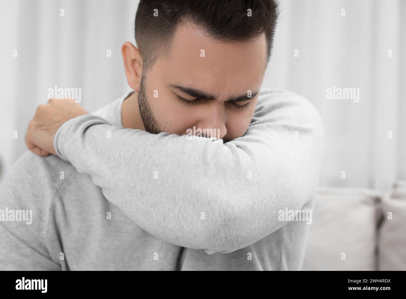Sick man coughing at home, closeup. Cold symptoms Stock Photo - Alamy