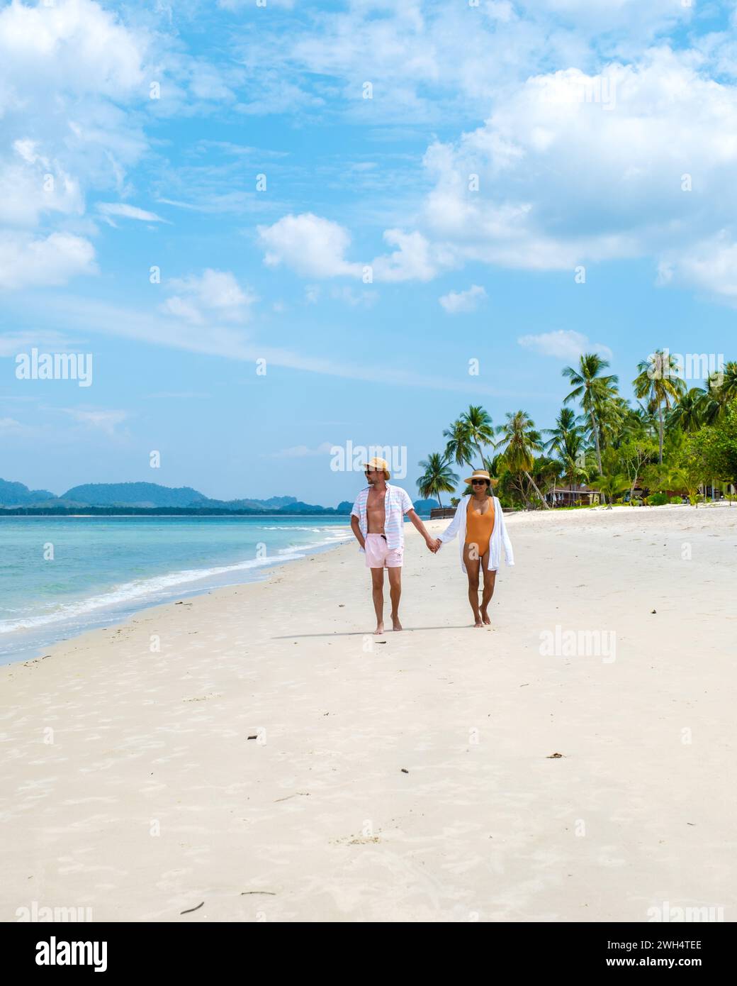 a young couple of caucasian men and a Thai Asian woman walking at the ...