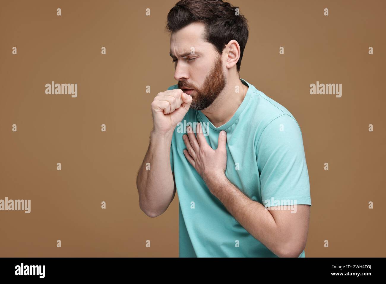 Sick man coughing on brown background. Cold symptoms Stock Photo - Alamy
